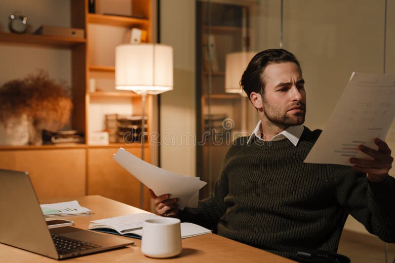 Young Puzzled Man Working with Laptop and Papers Stock Image - Image of ...