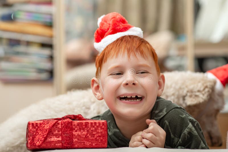 A Young Red-haired Boy Laughs Cheerfully in a New Year`s Hat Stock ...
