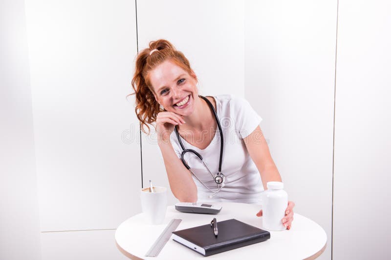 Young Red-haired Female Doctor in the Office Laughs at the Camera Stock ...