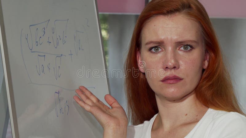 Young Red Haired Woman Looking Puzzled while Solving Math Problem Stock ...