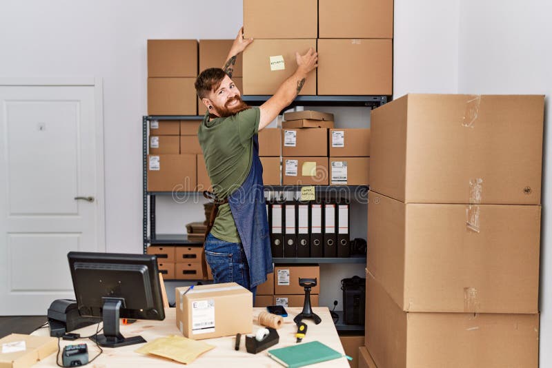 Young Redhead Man Business Worker Organizing Packages at Office Stock ...