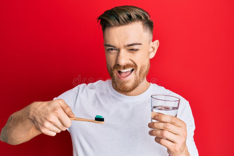 Young Redhead Man Holding Toothbrush with Toothpaste and Glass of Water ...