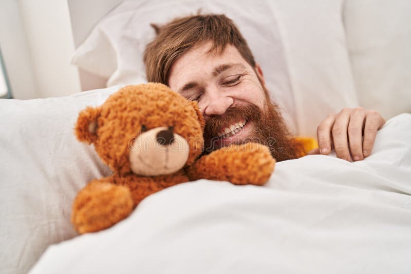 Young Redhead Man Lying on Bed Hugging Teddy Bear at Bedroom Stock ...