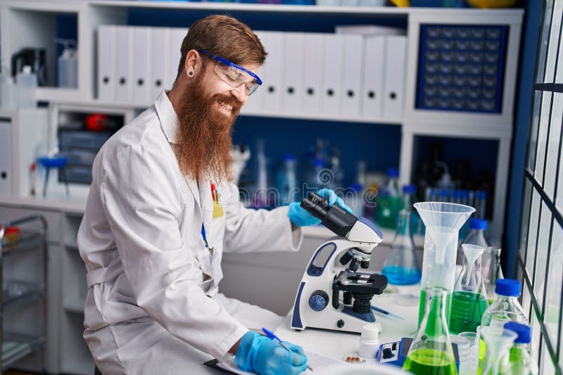Young Redhead Man Scientist Using Microscope Writing Report Working at ...