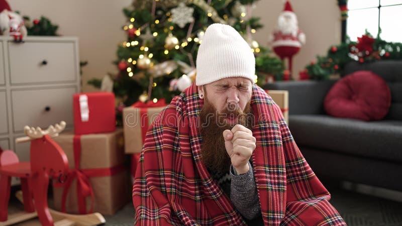 Young Redhead Man Sitting on Floor by Christmas Tree Coughing at Home ...