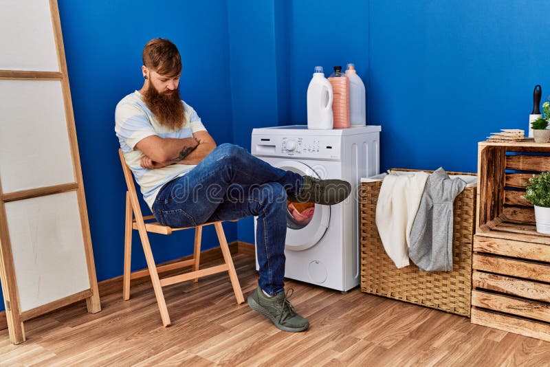 Young Redhead Man Tired Waiting for Washing Machine at Laundry Room ...
