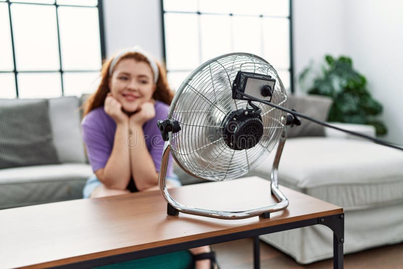 Young Redhead Woman Smiling Confident Using Electric Ventilator at Home ...