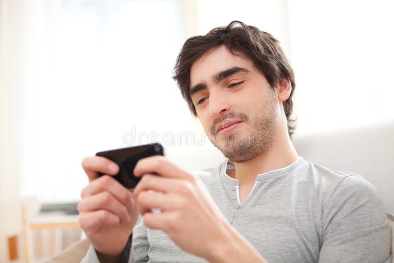 Young man writting SMS stock photo. Image of couch, home - 11413254