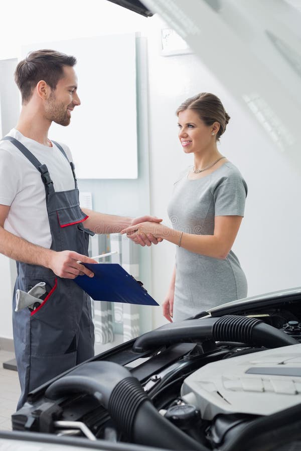 Young Repair Worker Shaking Hands with Customer in Car Workshop Stock ...