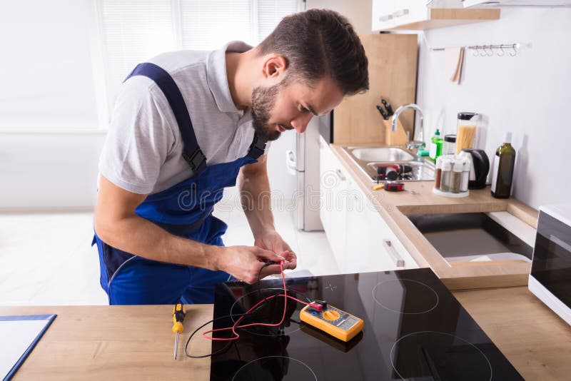 Young Repairman Fixing Induction Stove Stock Photo - Image of ...