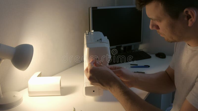 Young Repairman Master is Repairing Sewing Machine Sitting at Table ...