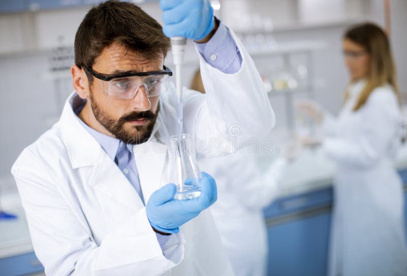 Young Researcher in Protective Workwear Standing in the Laboratory and ...