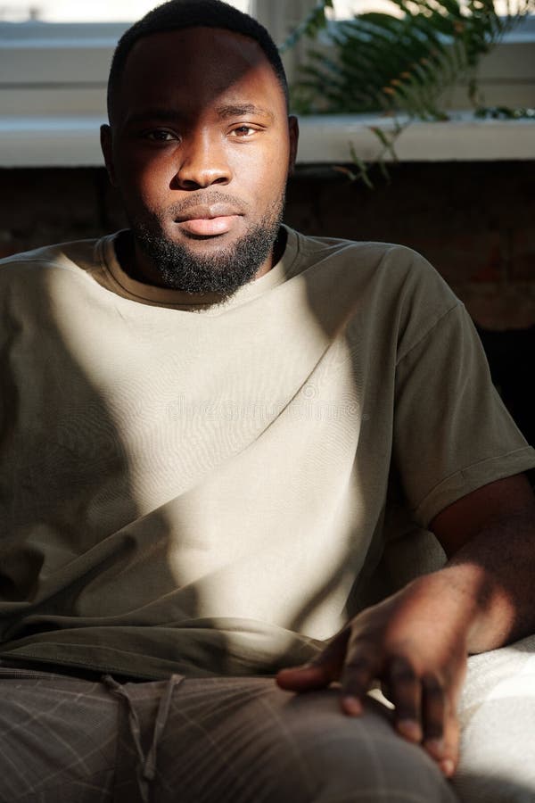 Young Restful Bearded Man of African Ethnicity Looking at You while ... Young Restful Bearded Man of African Ethnicity Looking at You while ...