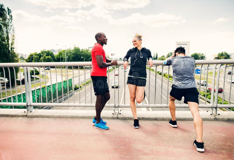 Young Runners in the City Resting on a Bridge. Stock Image - Image of ...