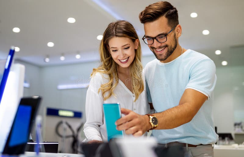 Young Satisfied Couple Testing the New Model of a Smart Cell Phone from ...