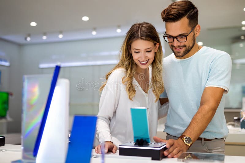 Young Satisfied Couple Testing the New Model of a Smart Cell Phone from ...