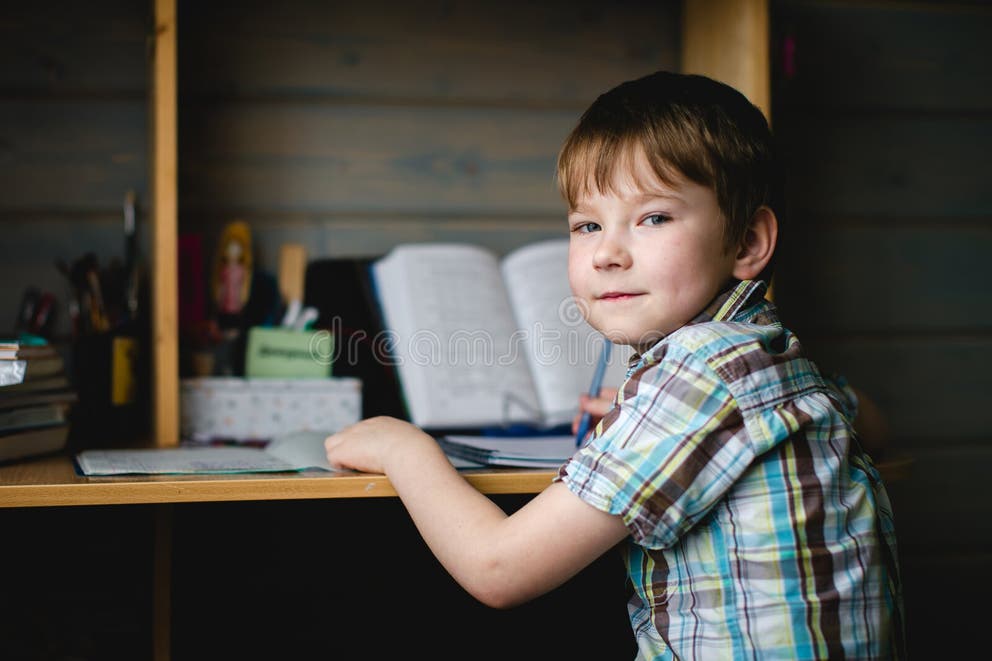 Young Schoolboy Does His Homework, Focused and Diligent at His Desk ...