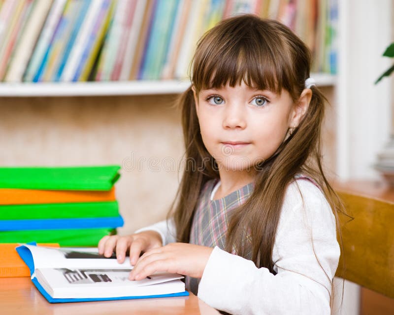 Young Schoolgirl Reading a Book. Looking at Camera Stock Image - Image ...