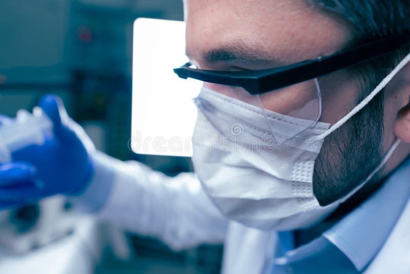 Young Scientist Checking Test Tubes in the Lab. Man Wears Protective ...