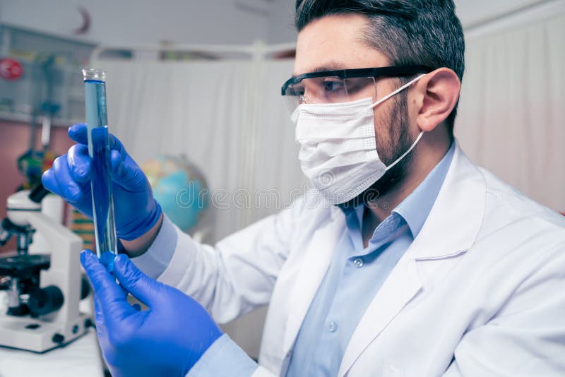 Young Scientist Checking Test Tubes in the Lab. Man Wears Protective ...
