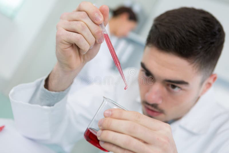 Young Scientist Dripping Liquid from Pipette Stock Photo - Image of ...