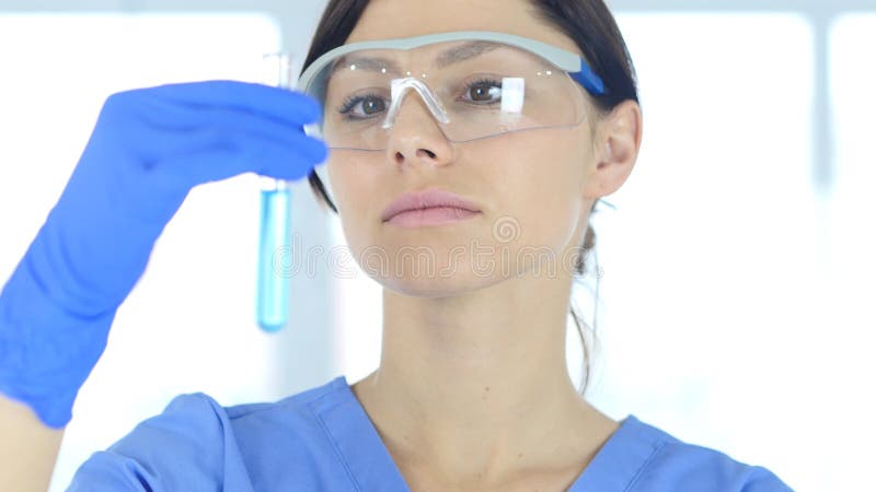 Young Scientist Looking at Blue Solution in Test Tube in Laboratory ...