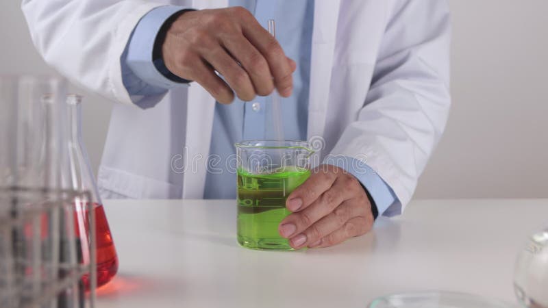 Young Scientist Man Stir Green Solution in Beaker for Testing in Lab ...