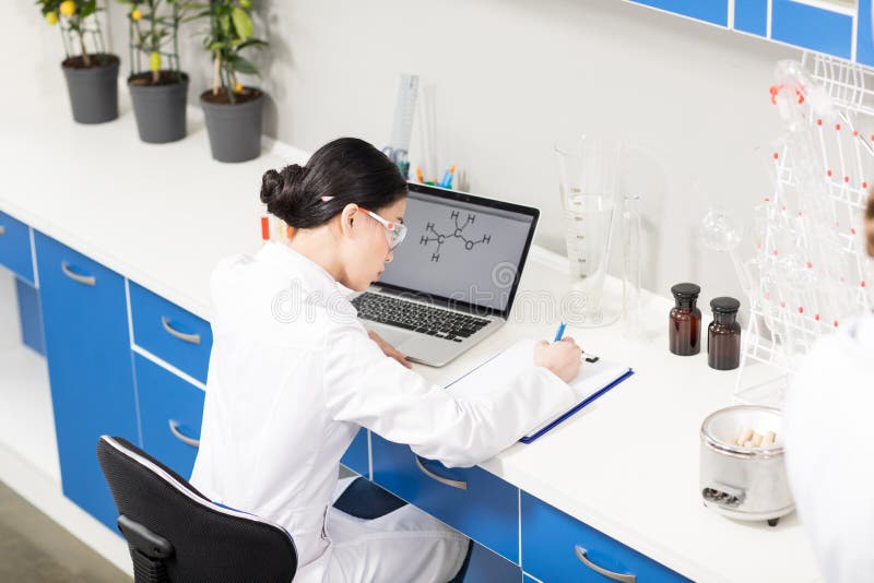 Young Scientist Using Laptop and Writing in Clipboard in Research ...