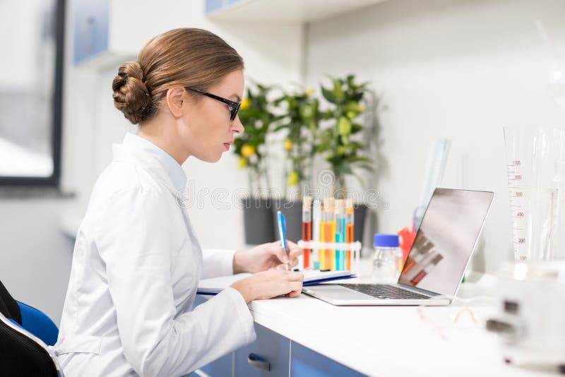 Young Scientist Using Laptop and Writing in Clipboard in Research ...