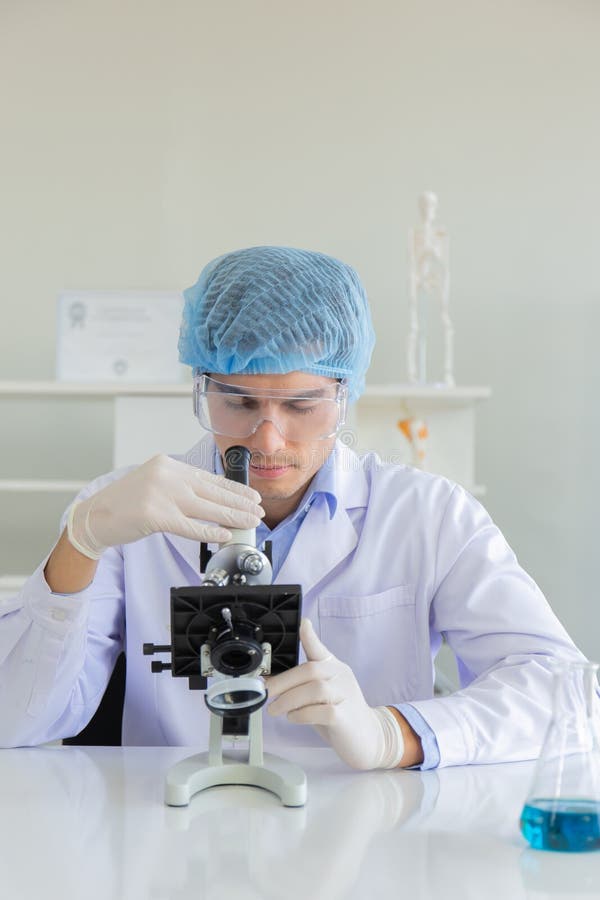 Young Scientist Using Microscope in Laboratory. Male Researcher Wearing ...