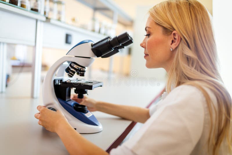 Young Scientist Woman Working with Microscope in a Laboratory Stock ...