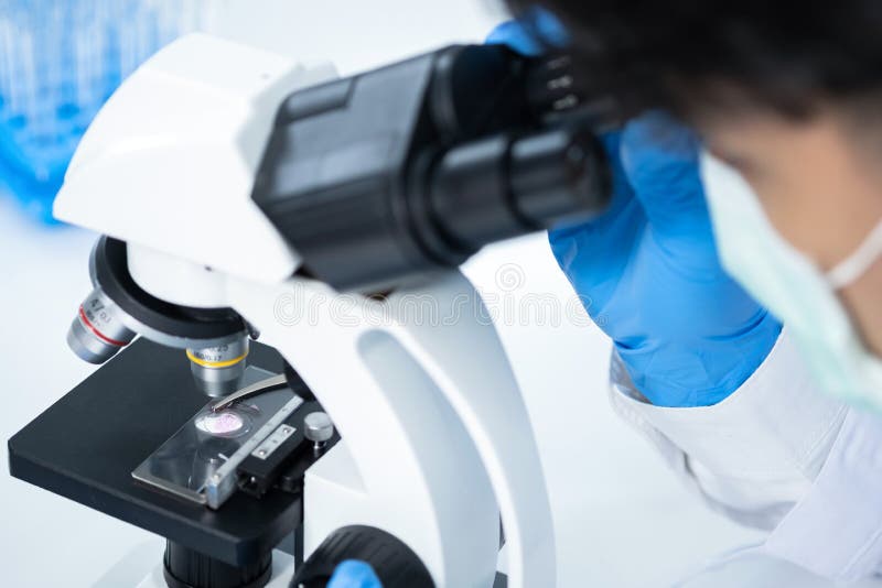 Young Scientists in a Lab Coat and Wear a Hygiene Mask Using a ...
