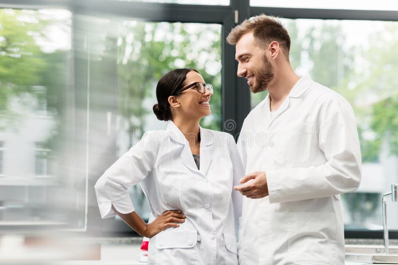 Young Scientists in White Coats Smiling Each Other in Lab Stock Photo ...