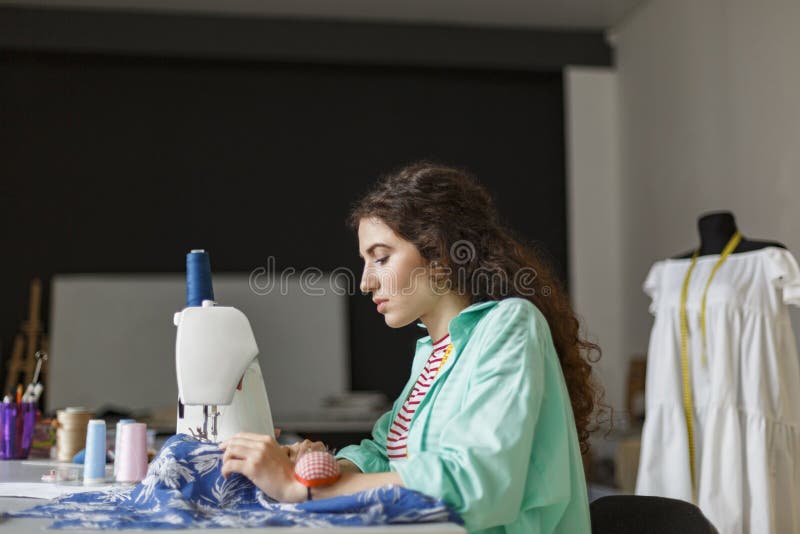 Young Seamstress in Colorful Shirt Thoughtfully Working with Sewing ...