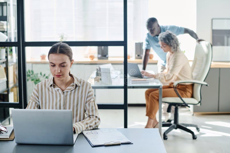 Young Secretary or Analyst Using Laptop while Sitting by Desk with ...