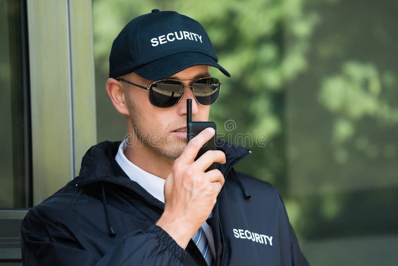 Young Security Guard Talking on Walkie-talkie Stock Image - Image of ...