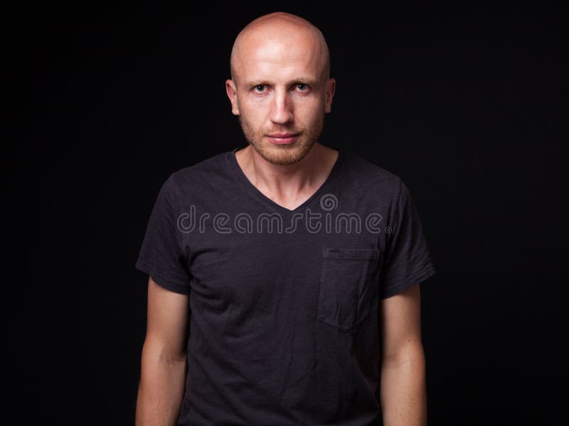 A Serious, Bald, Middle-aged Man in a Strict Black Suit Sits and Stares ...
