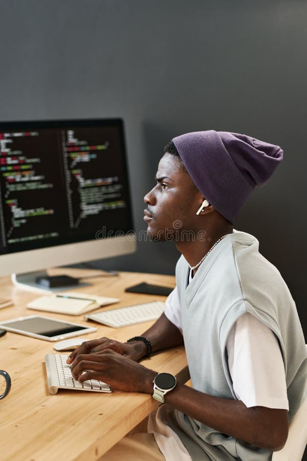 Young Serious it Engineer with Earphones Looking at One of Computer ...