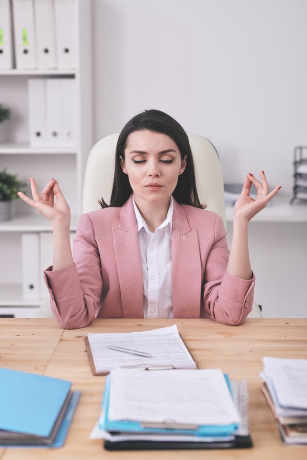 Young Serious Female Office Manager Practicing Yoga by Desk at Break ...
