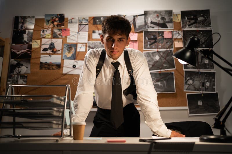 Young Serious Male Detective in Uniform Bending Over Workplace with ...