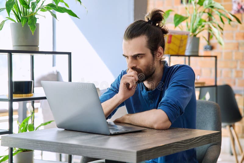 Young Serious Man Working, Studying Using Laptop Sitting in Coworking ...