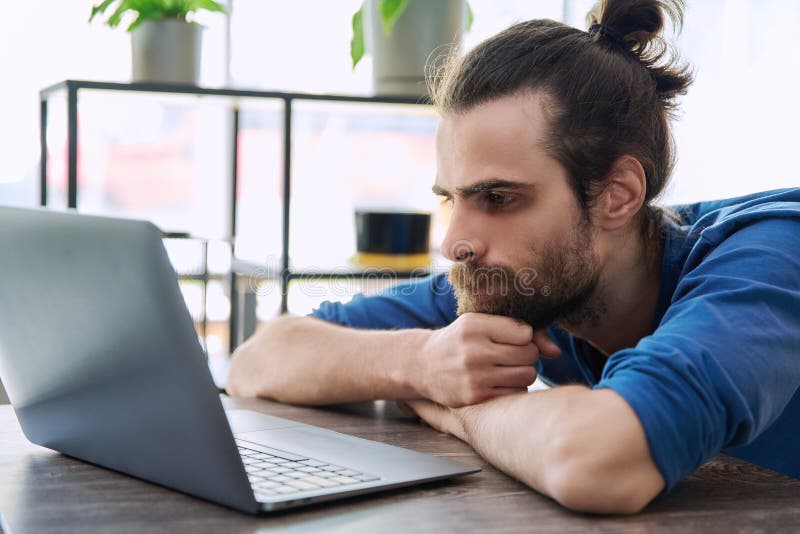 Young Serious Man Working, Studying Using Laptop Sitting in Coworking ...