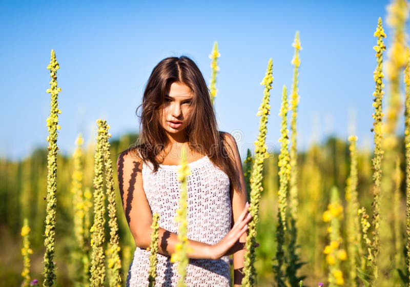 Young Woman In White Mini Dress Standing With Eyes Closed And Enjoying