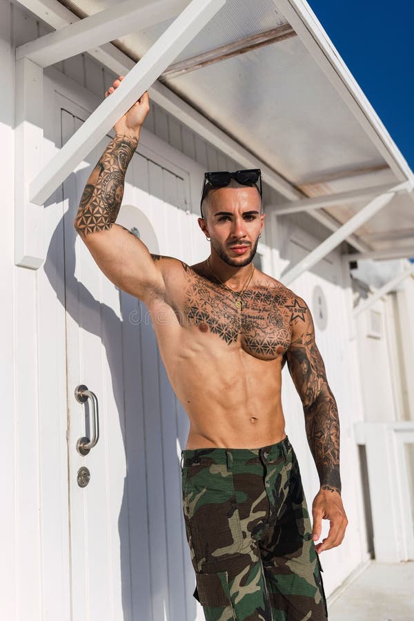 Young, Shirtless Man with Tattoos Posing in Front of a Beach Hut Stock ...