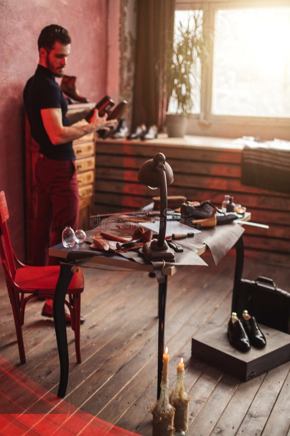 Young Shoemaker Standing Near the Desk with Useful Tools in Workshop ...