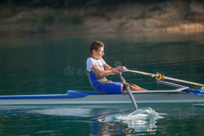 A Young Single Scull Rowing Competitor Paddles on the Tranquil Lake ...