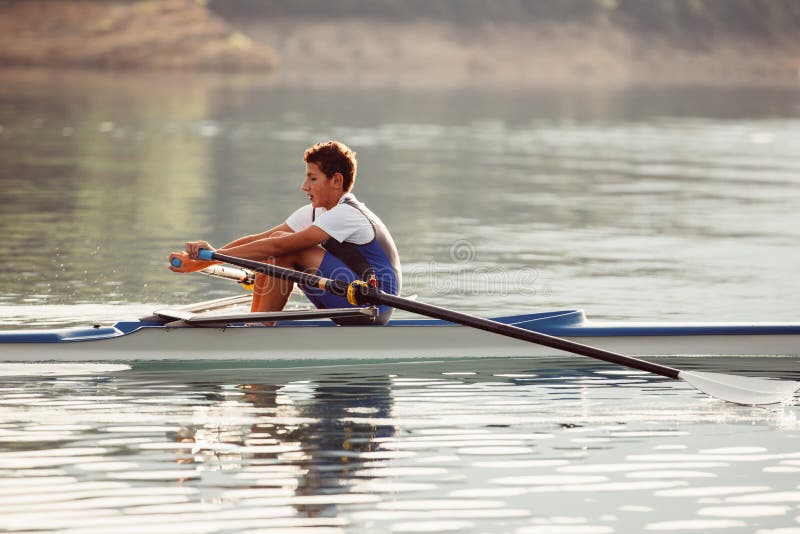 A Young Single Scull Rowing Competitor Paddles on the Tranquil Lake ...