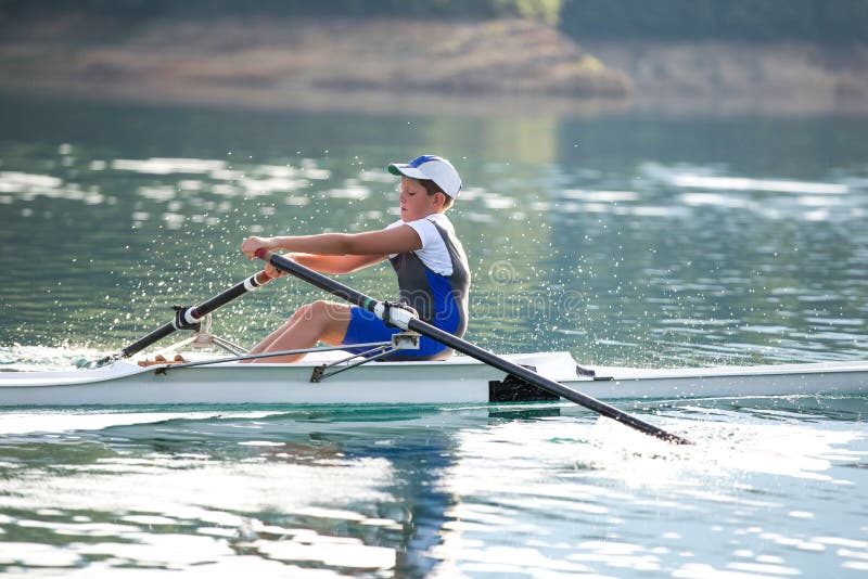 A Young Single Scull Rowing Competitor Paddles on the Tranquil Lake ...