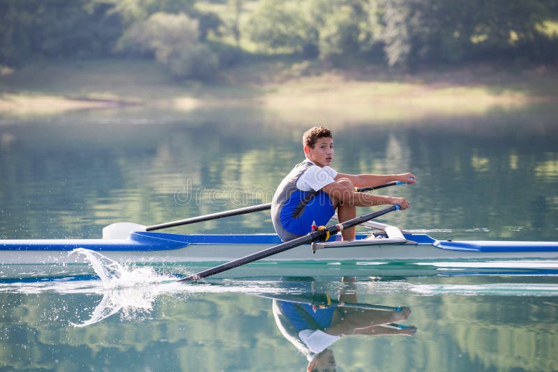 A Young Single Scull Rowing Competitor Paddles on the Tranquil Lake ...