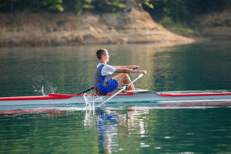 A Young Single Scull Rowing Competitor Paddles on the Tranquil Lake ...